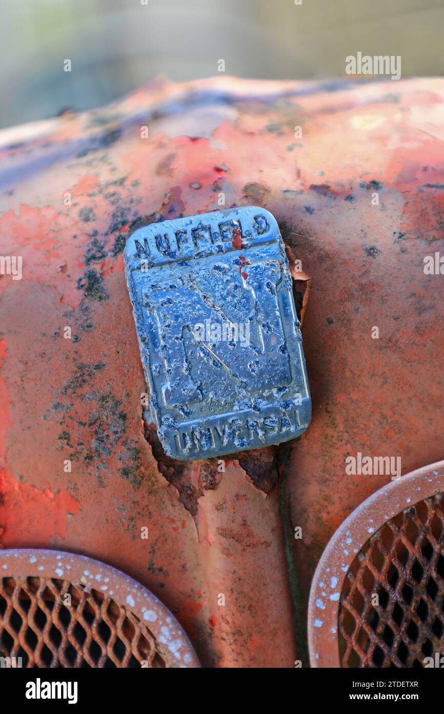 A badge on a rusty derelict Nuffield Universal tractor abandoned on a ...