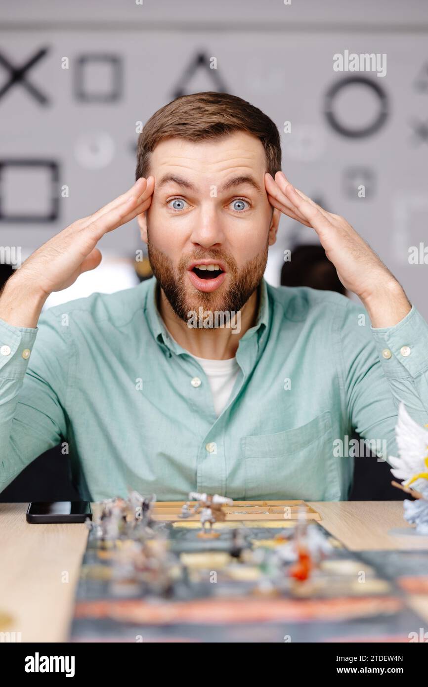 Man with board game piece while practicing strategy in home alone. A ...