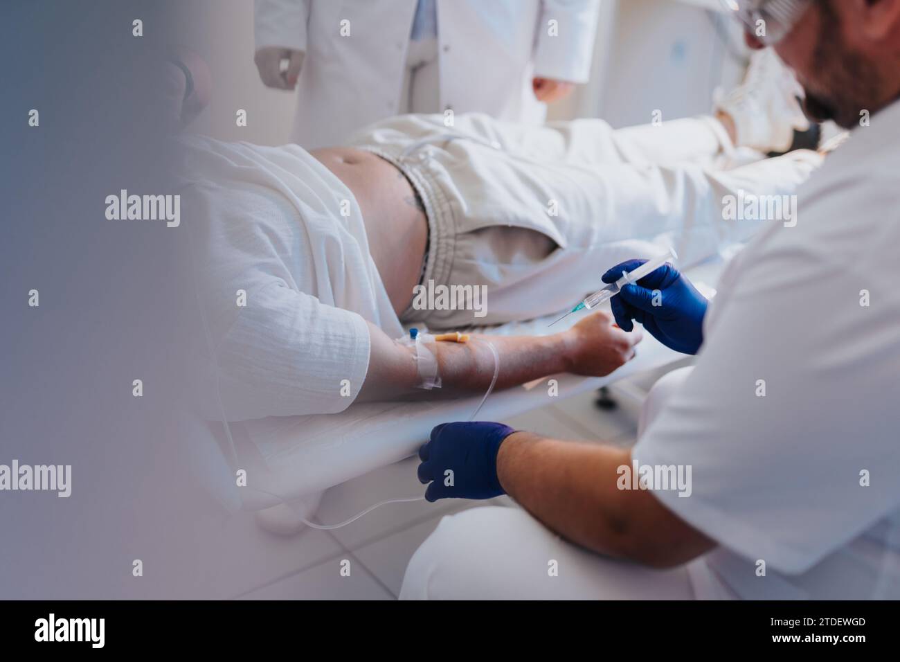 In a hospital room, a patient receives infusion therapy from a doctor ...