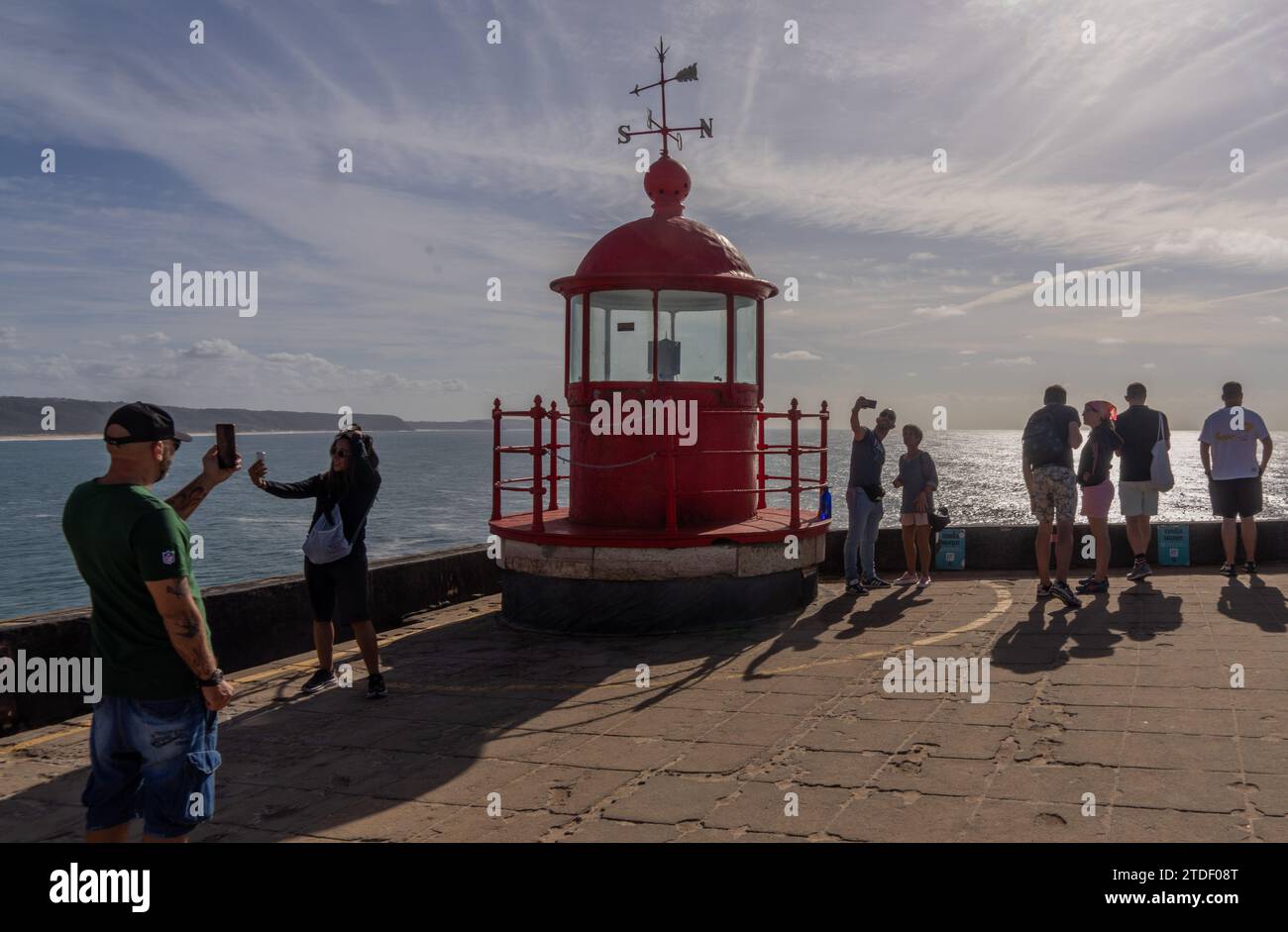 View of windy surfing north beach, fort and lighthouse in Nazare, host ...