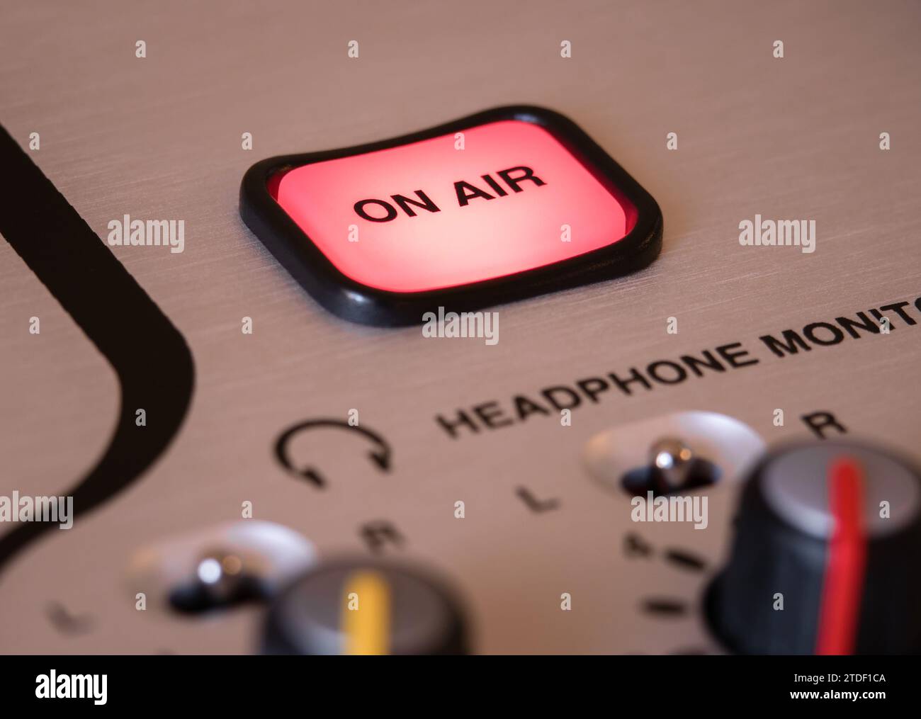 Glowing red "ON AIR" button on the broadcast studio's digital console ...
