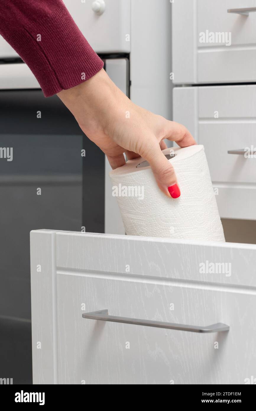 woman taking out paper towel from kitchen drawer. paper towel in the ...