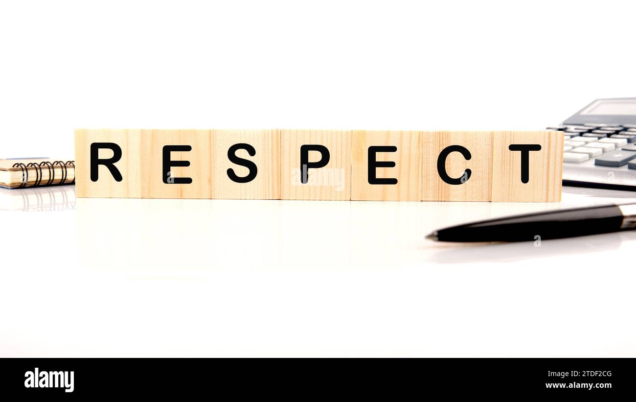 respect word assembled from wooden cubes next to a calculator, pen and ...