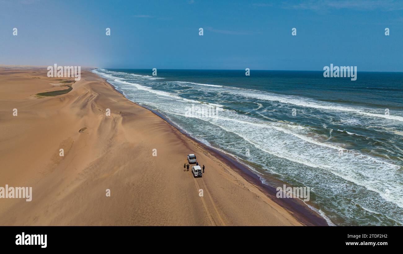 Cars driving on the ridge of the sanddunes along the Atlantic, Namibe ...