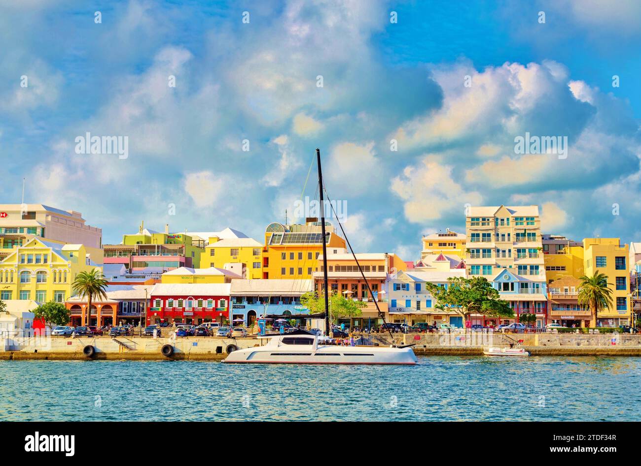 Catamaran passing pastel coloured buildings on Front Street, Hamilton ...