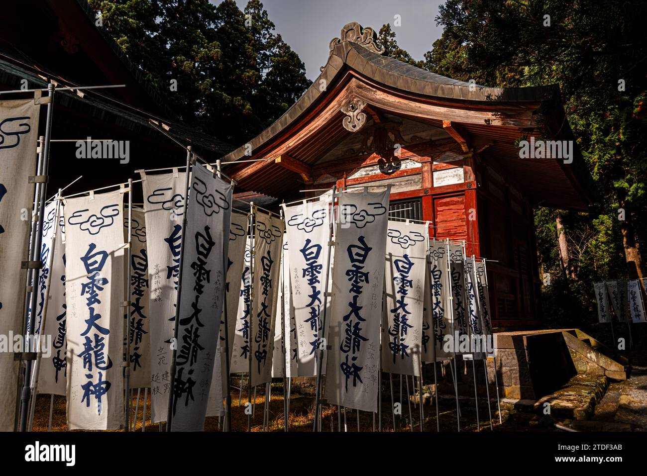 White banners with kanji written on it at The Mount Iwaki Shrine, near ...