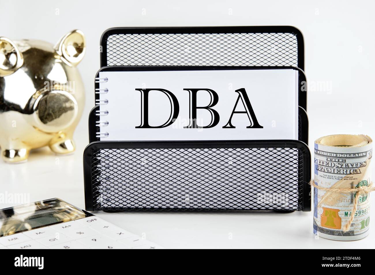 DBA text on a white piece of paper next to a piggy bank, a roll of ...