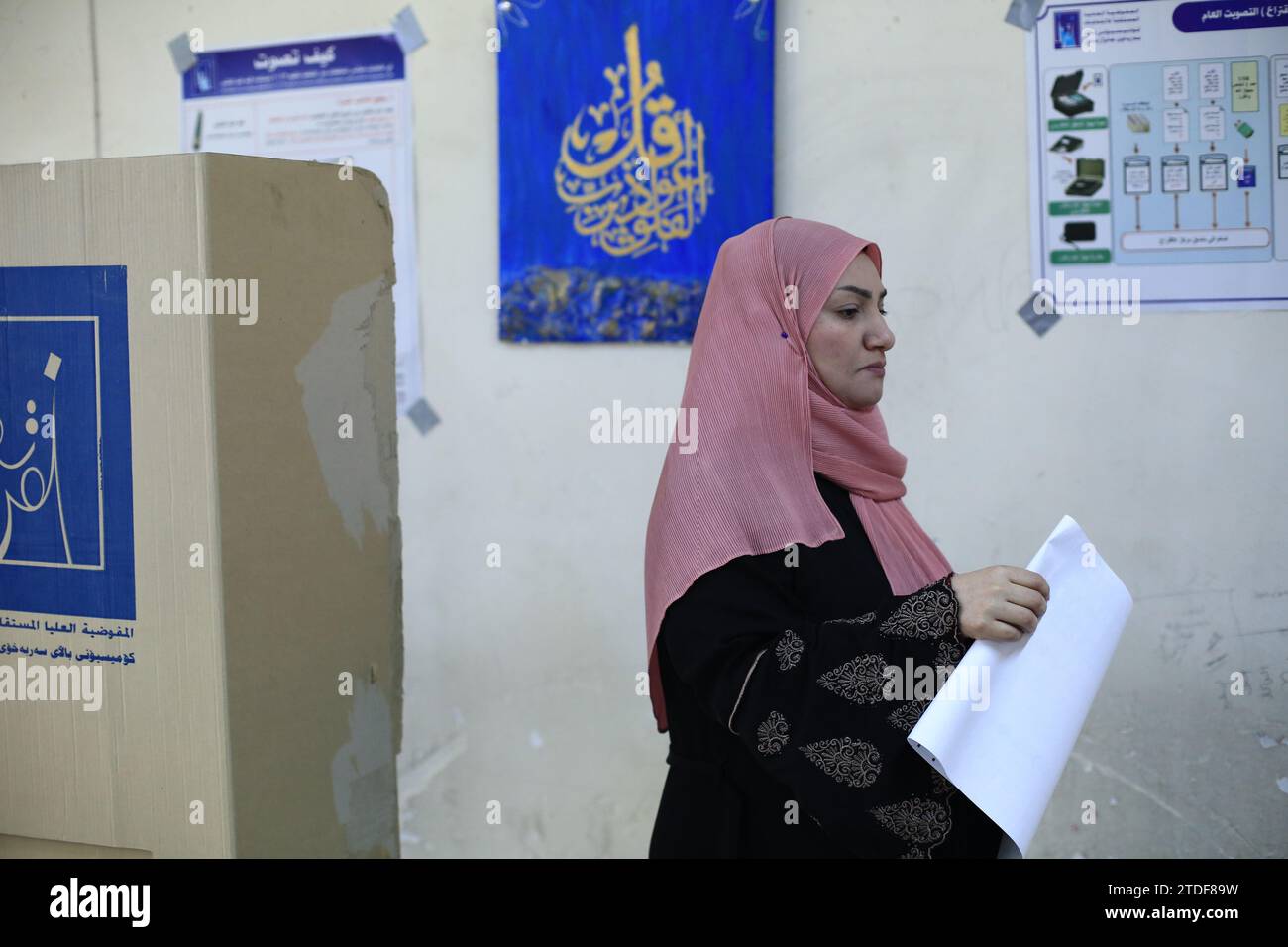 Baghdad, Iraq. 18th Dec, 2023. An Iraqi woman casts her vote in the ...
