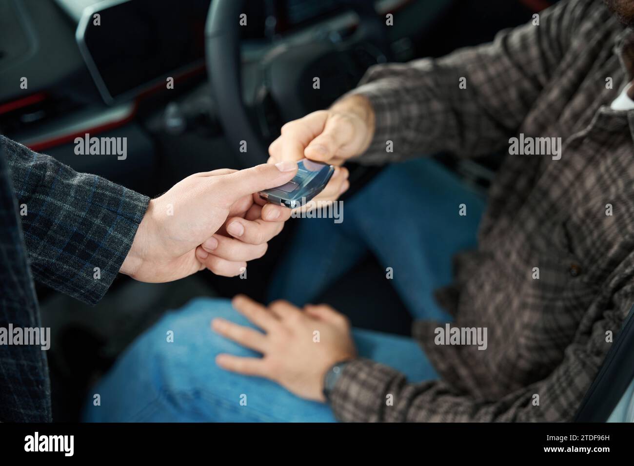 Salesperson working customer at car dealership giving keys to new car ...