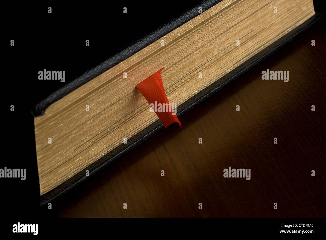 Red bookmark bookmark in old book with golden cover closed horizontally ...