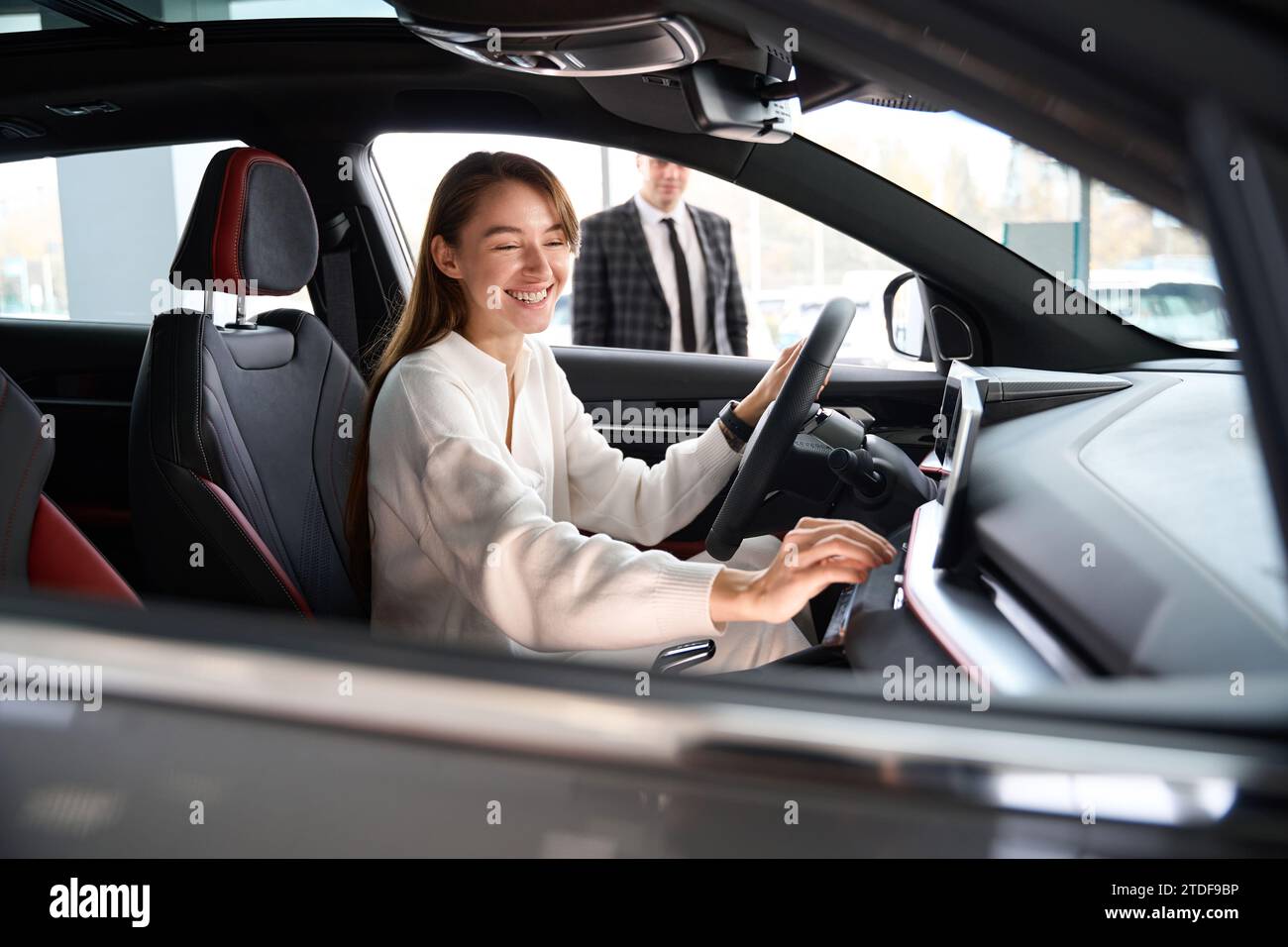Woman customer siting in new car talking with automobile seller in ...