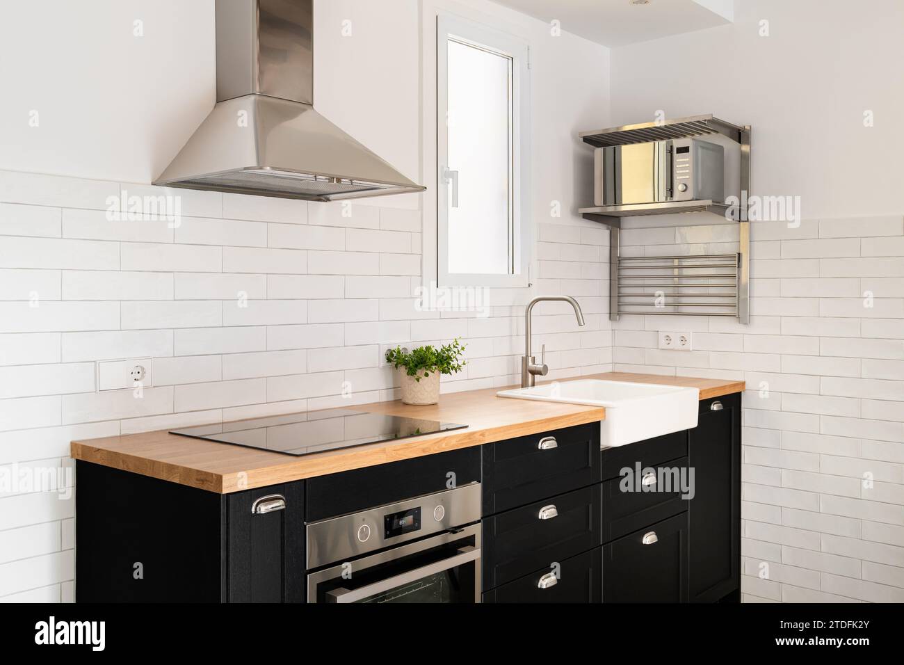 Kitchen island with convection hob and oven with black drawers and wood ...