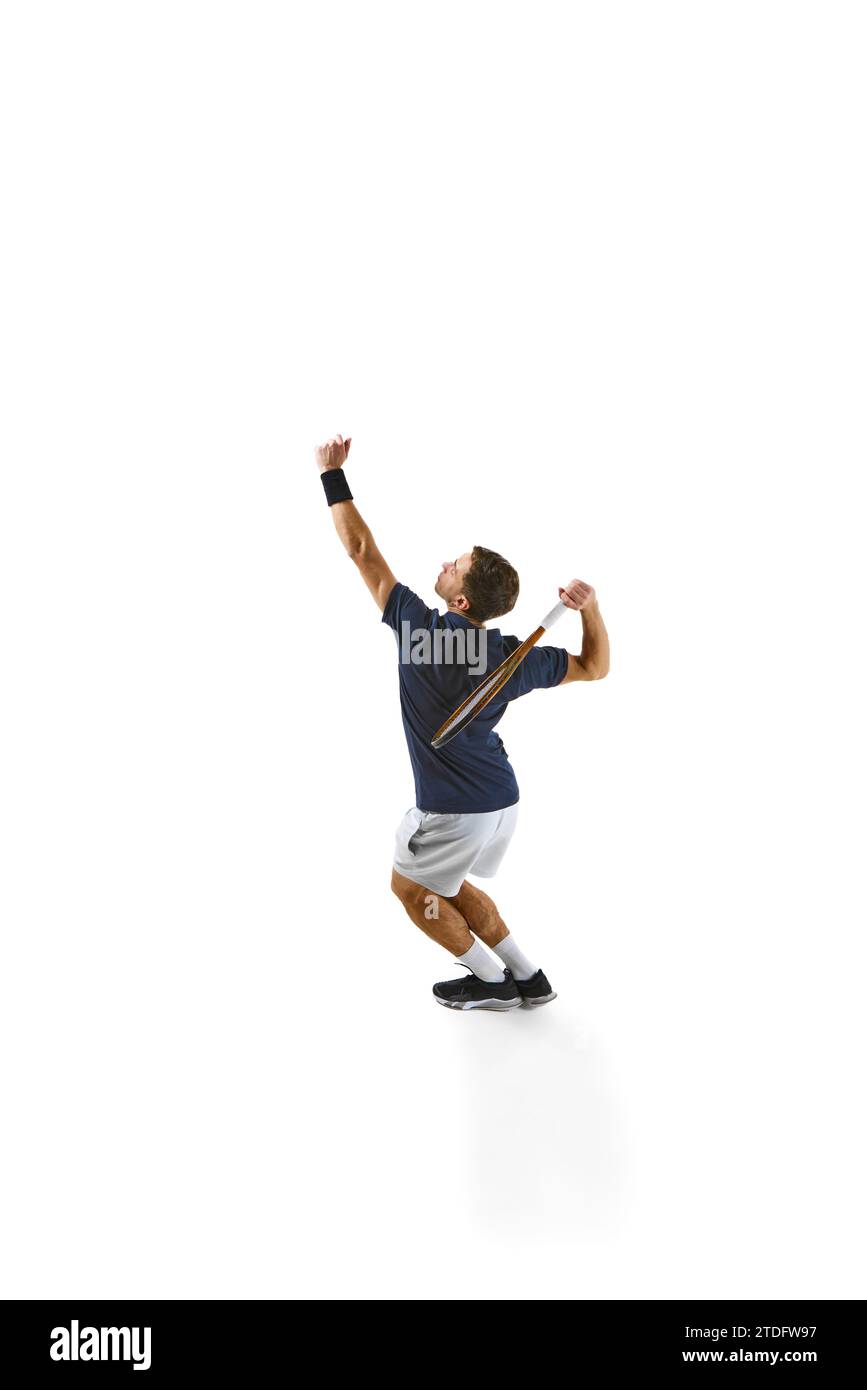 Competitive man in his 30s, tennis player in motion, hitting ball with ...