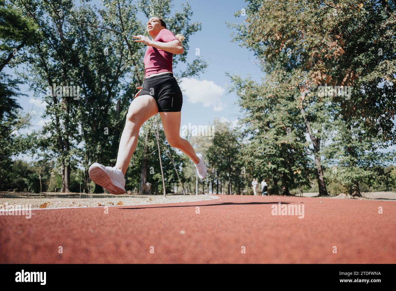 Fit woman in the park, running and having fun on a sunny day. She ...