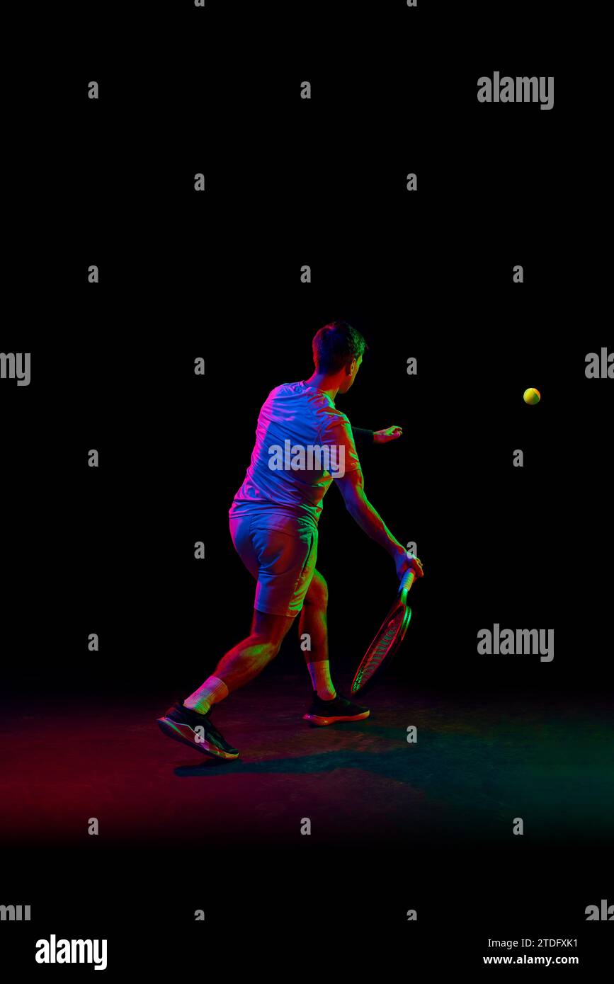 Dynamic image of man, athlete in motion, playing tennis, serving ball ...