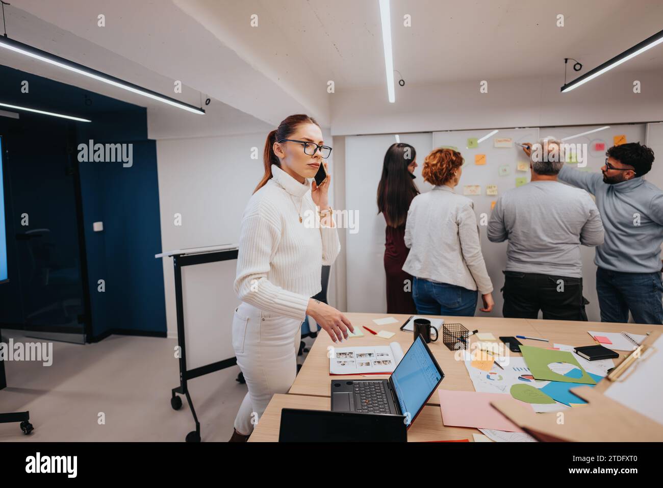 Different aged, business professionals collaborating and sharing ideas ...