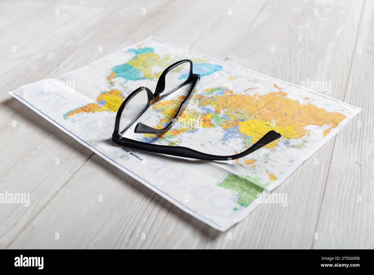 World map and glasses on the table. Geography learning concept ...