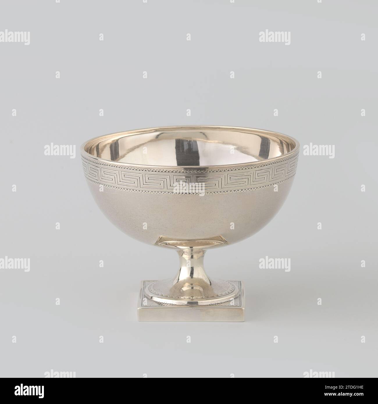 Silver coil, on square, straight -walled base. Decorated with ...