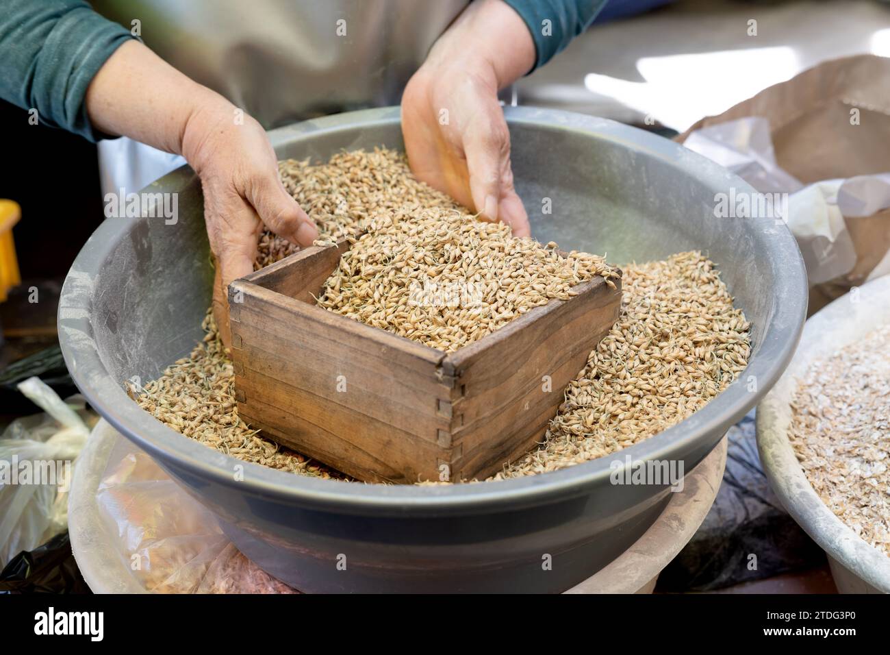 A merchant's hands arranging malt on display for sale at a Korean ...