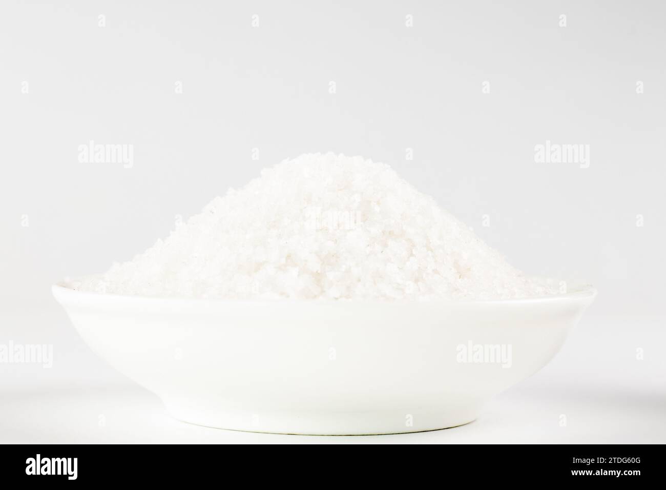 table salt in white bowl isolated on white background.eye level shot ...