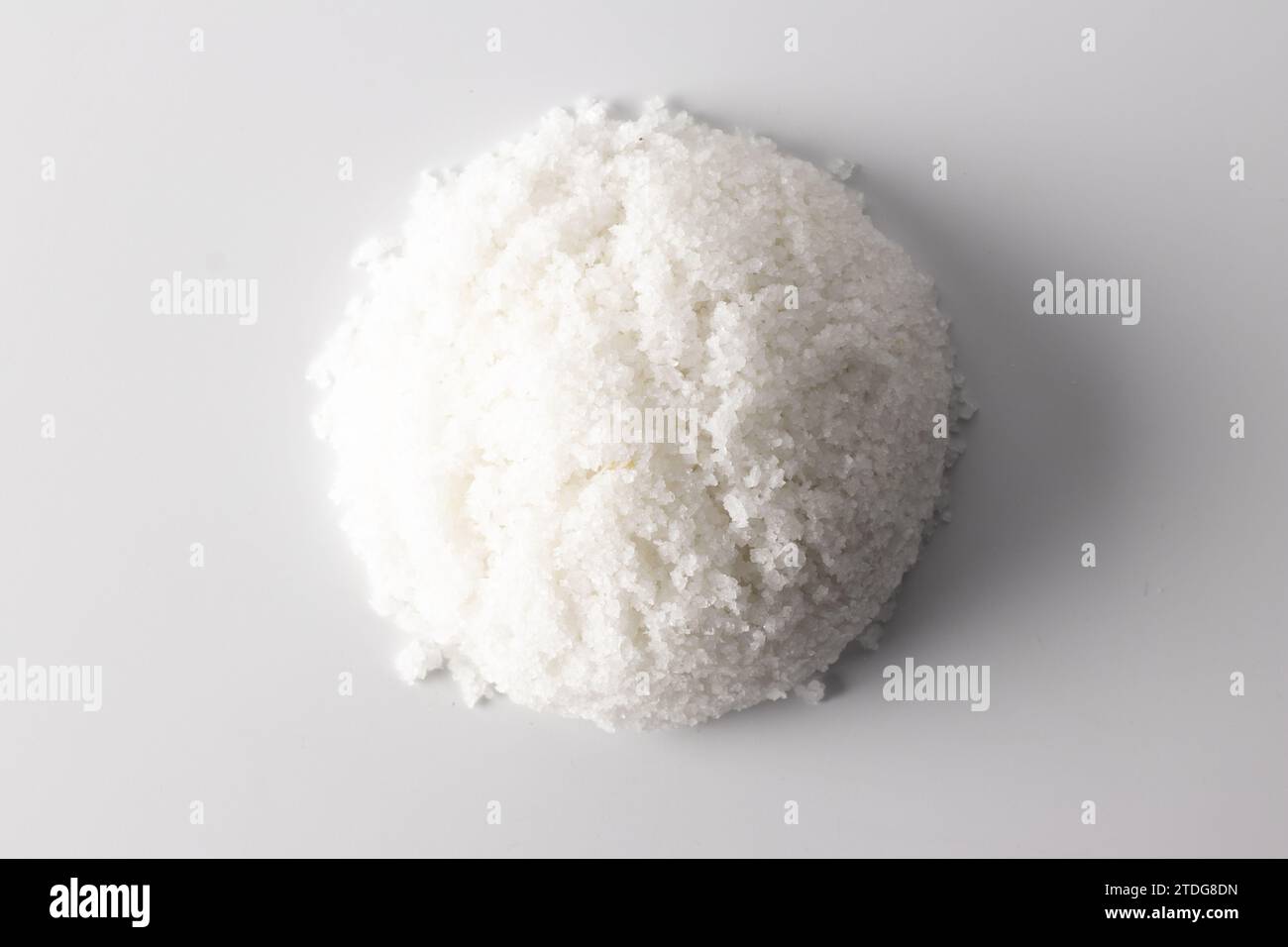 Finely ground white sea salt piled in circle shape isolated on white ...