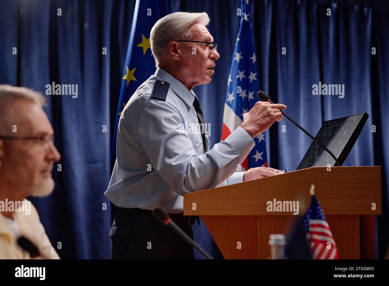Mature politician speaking in microphone while performing at military ...