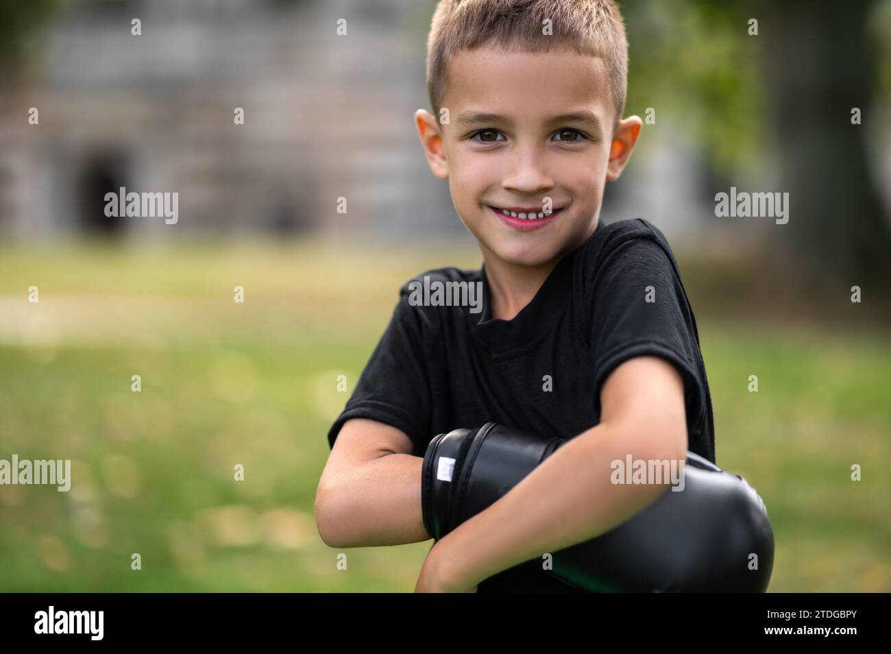 Cute boy in boxing gloves looking contented and excited Stock Photo - Alamy