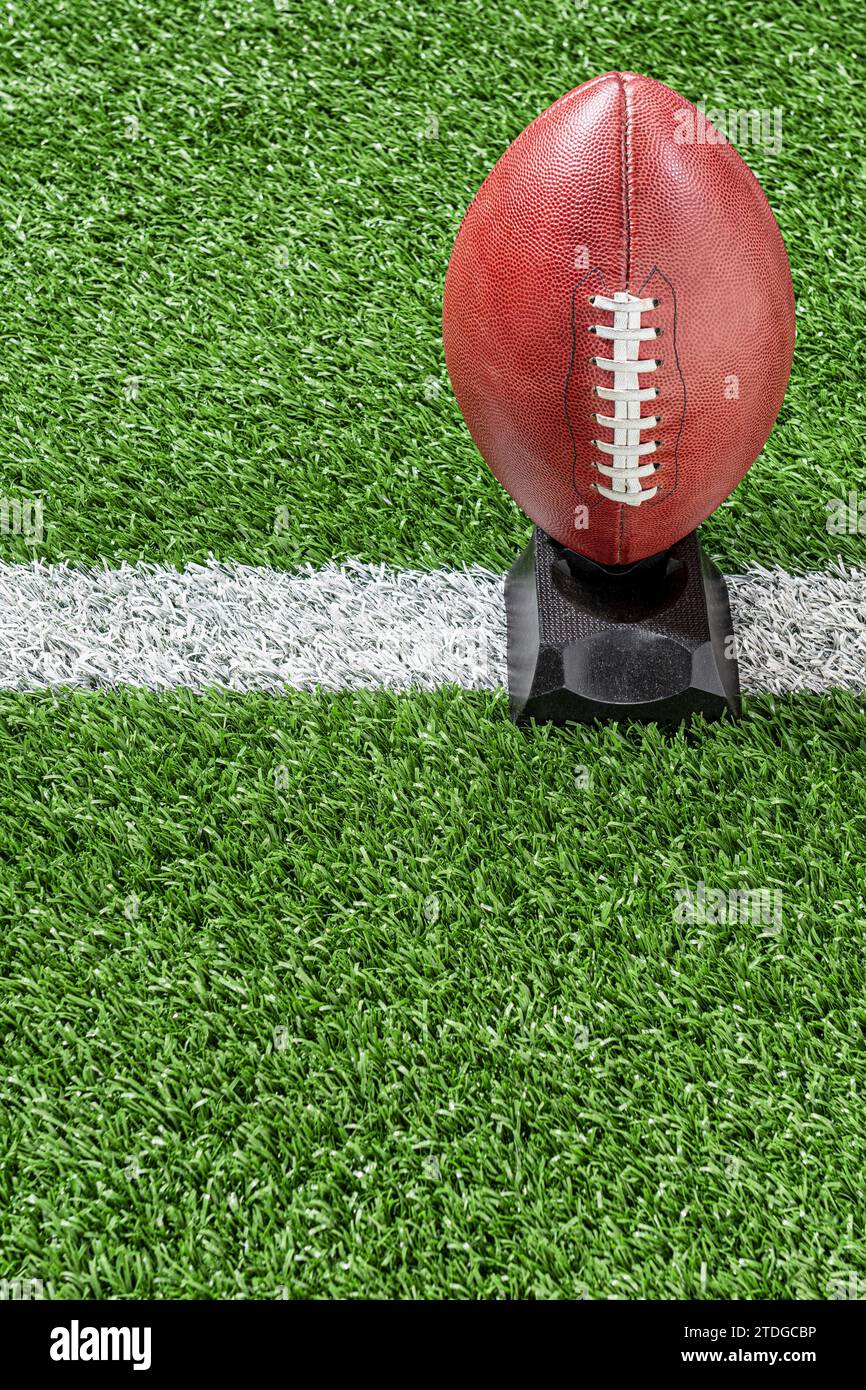 An American football on kicking tee with yard line Stock Photo - Alamy
