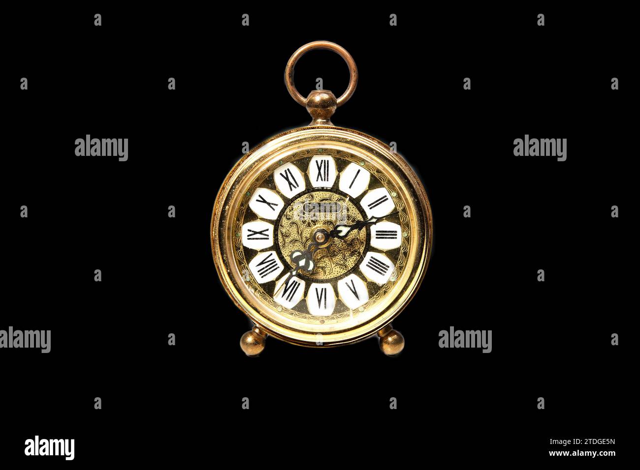 an old golden analog alarm clock with mechanical movement isolated on ...
