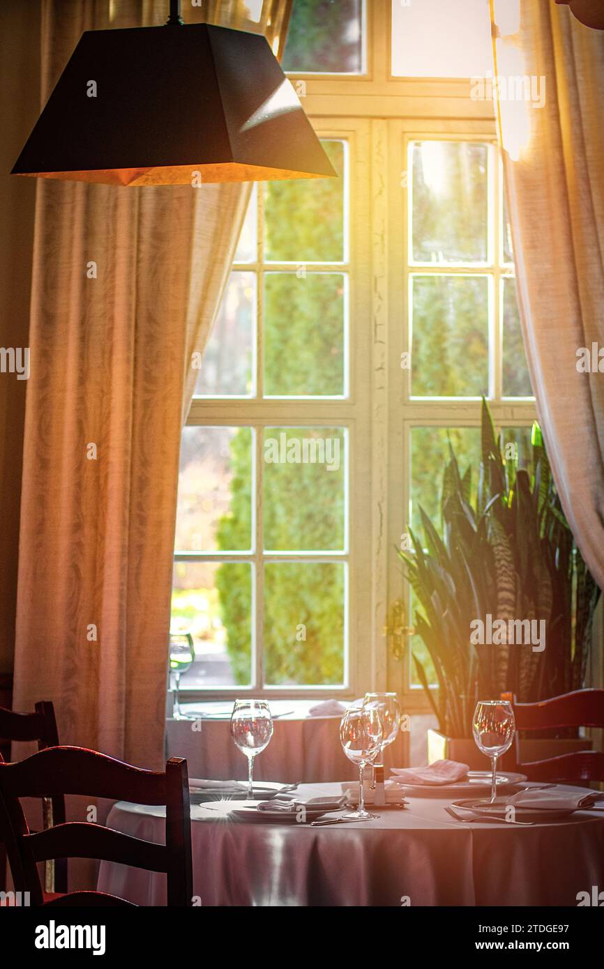Dining table set with wine glasses by the window in a luxury restaurant ...