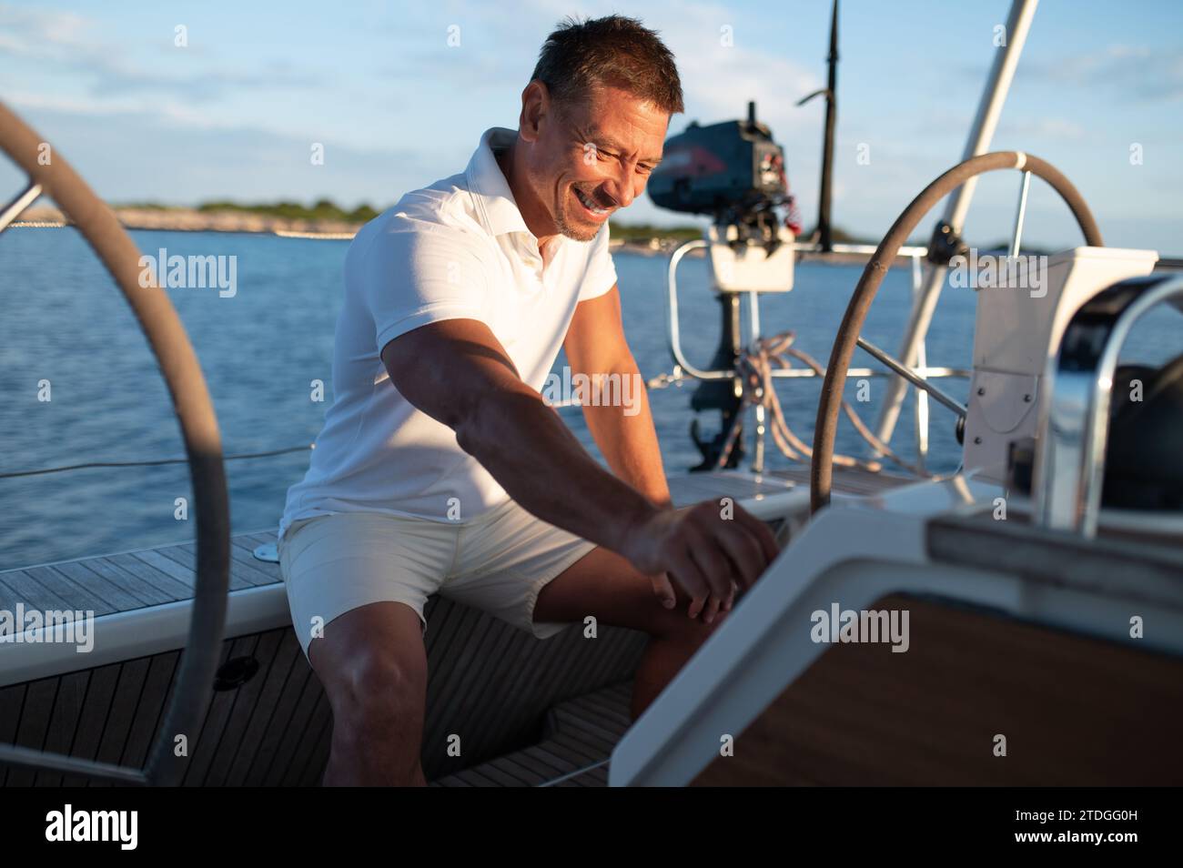 Man in white clothes sailing on a yacht Stock Photo - Alamy