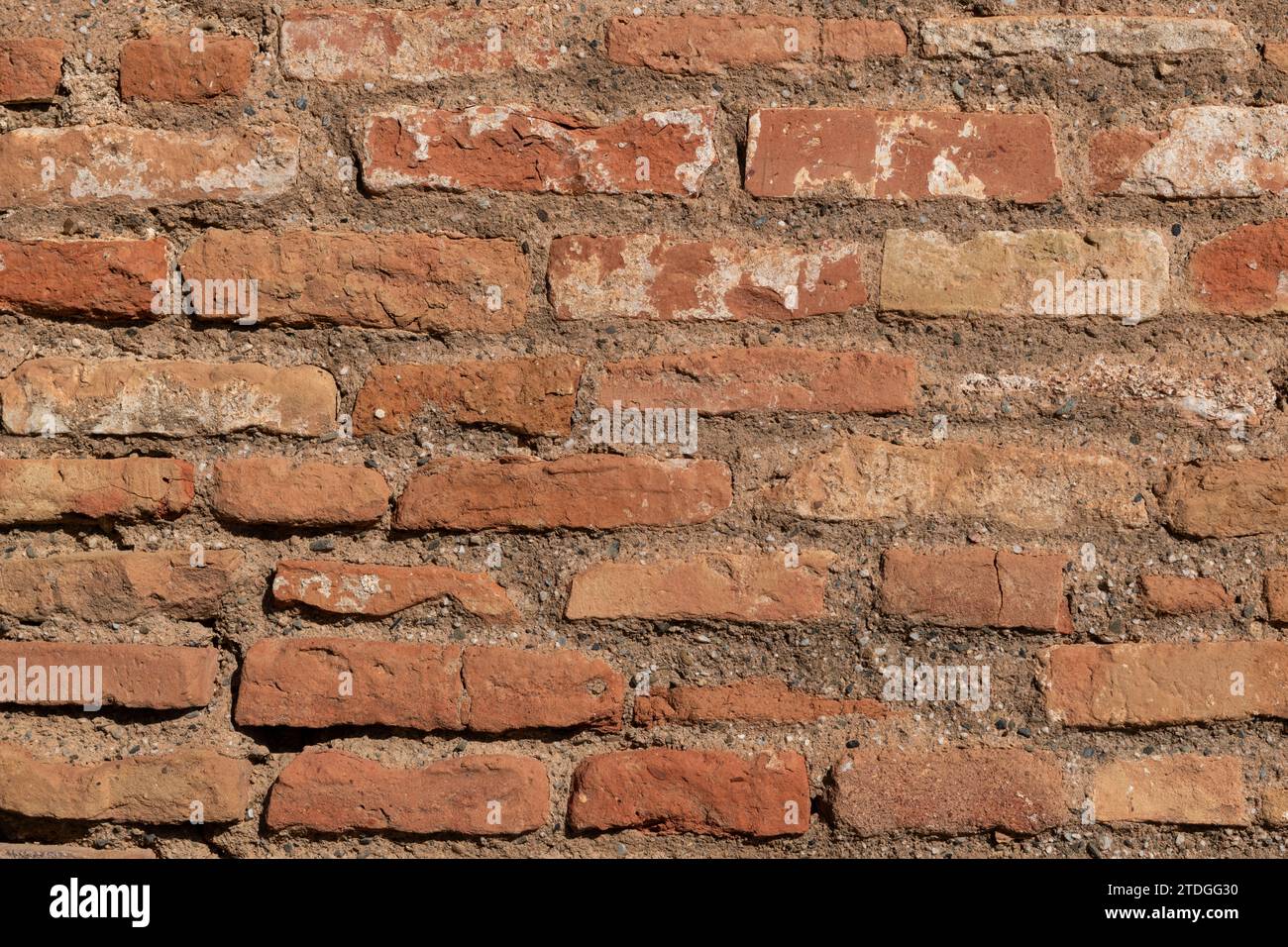 Closeup detail of a section of an old, red brick wall that is worn ...