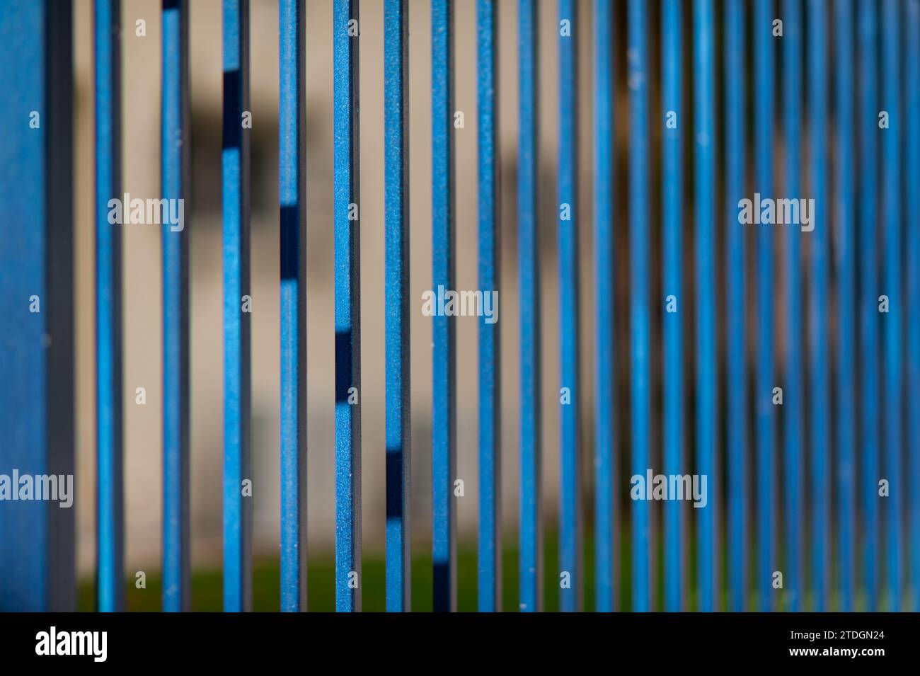 Abstract closeup detailed view of a blue, metal fence in shadow and ...