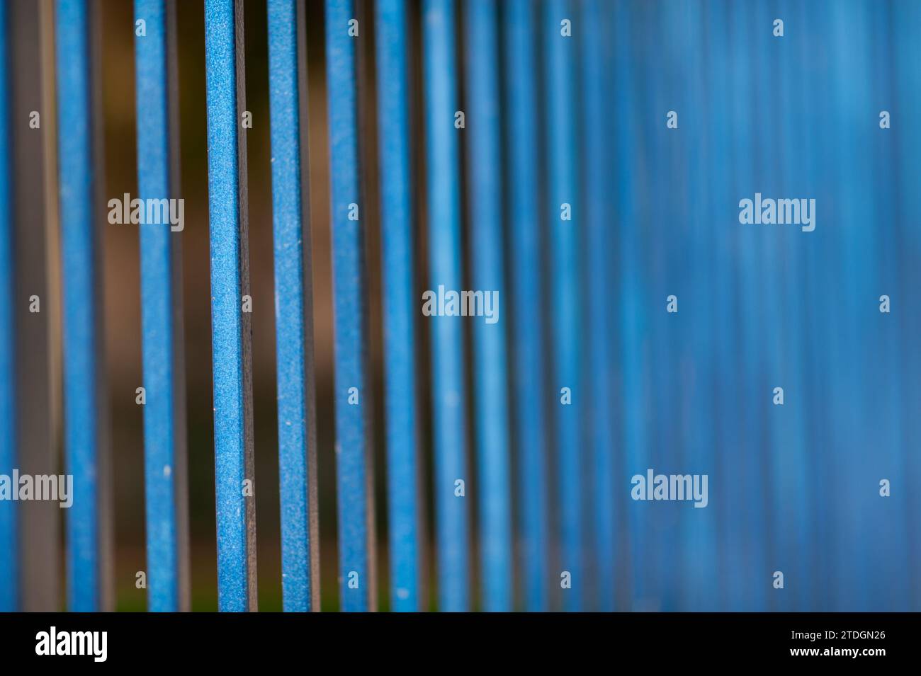 Abstract closeup detailed view of a blue, metal fence in shadow and ...