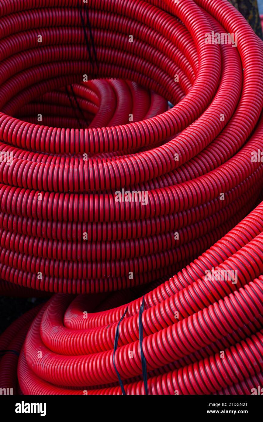 Several large coils of red plastic hosing used for laying irrigation ...