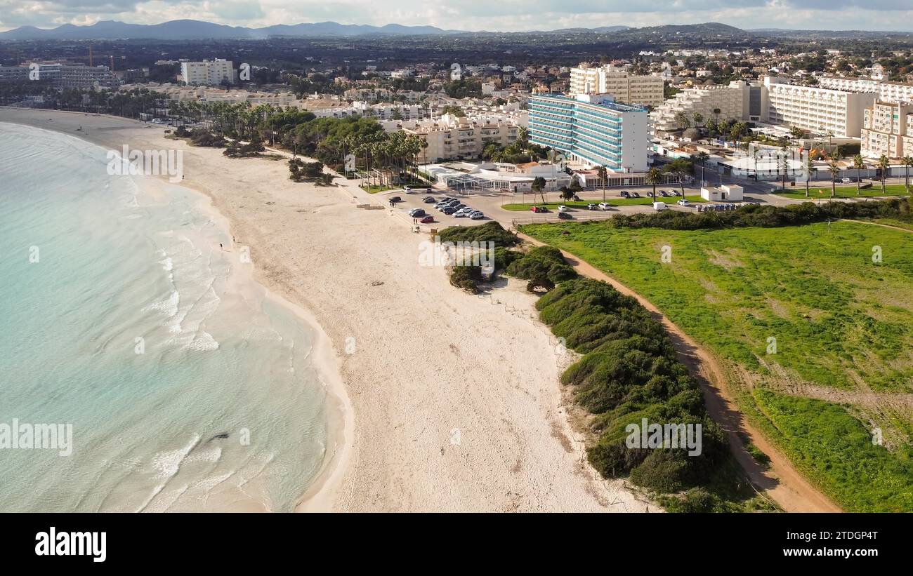 Aerial view of a sunny coastline with waves hitting the sandy shore ...