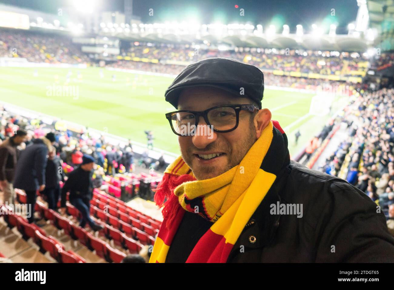 A football fan stands is in the stadium of Watford Football Club, with ...