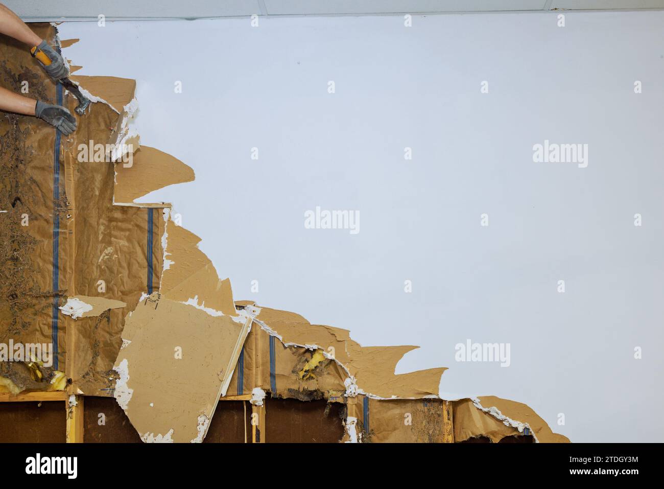 Dismantling old damaged plasterboard drywall during house ...