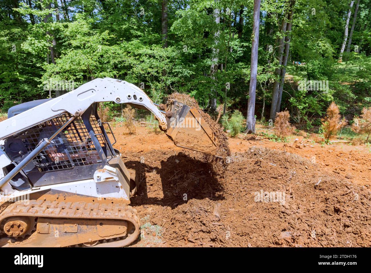 An using mini bulldozer capable of moving soil, working with earth ...