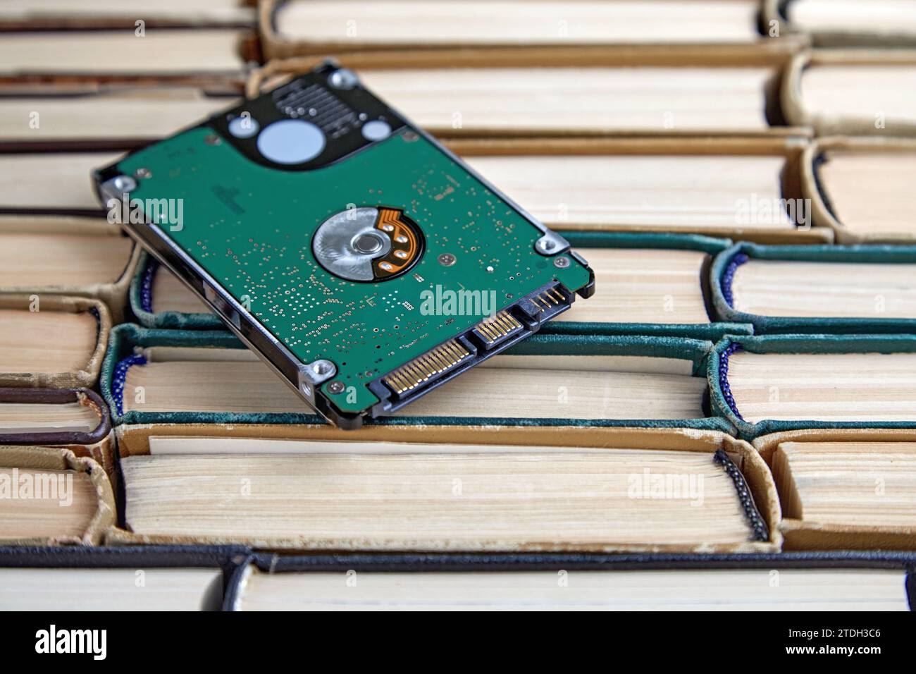 Hard drive on a stack of old shabby paper books. Comparison of storage ...