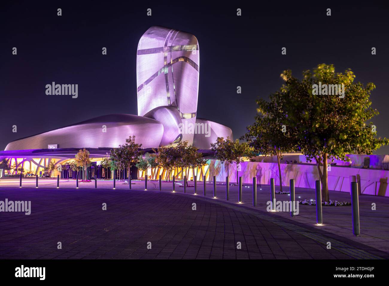 Illuminated modern building and square with trees in the center of Al ...