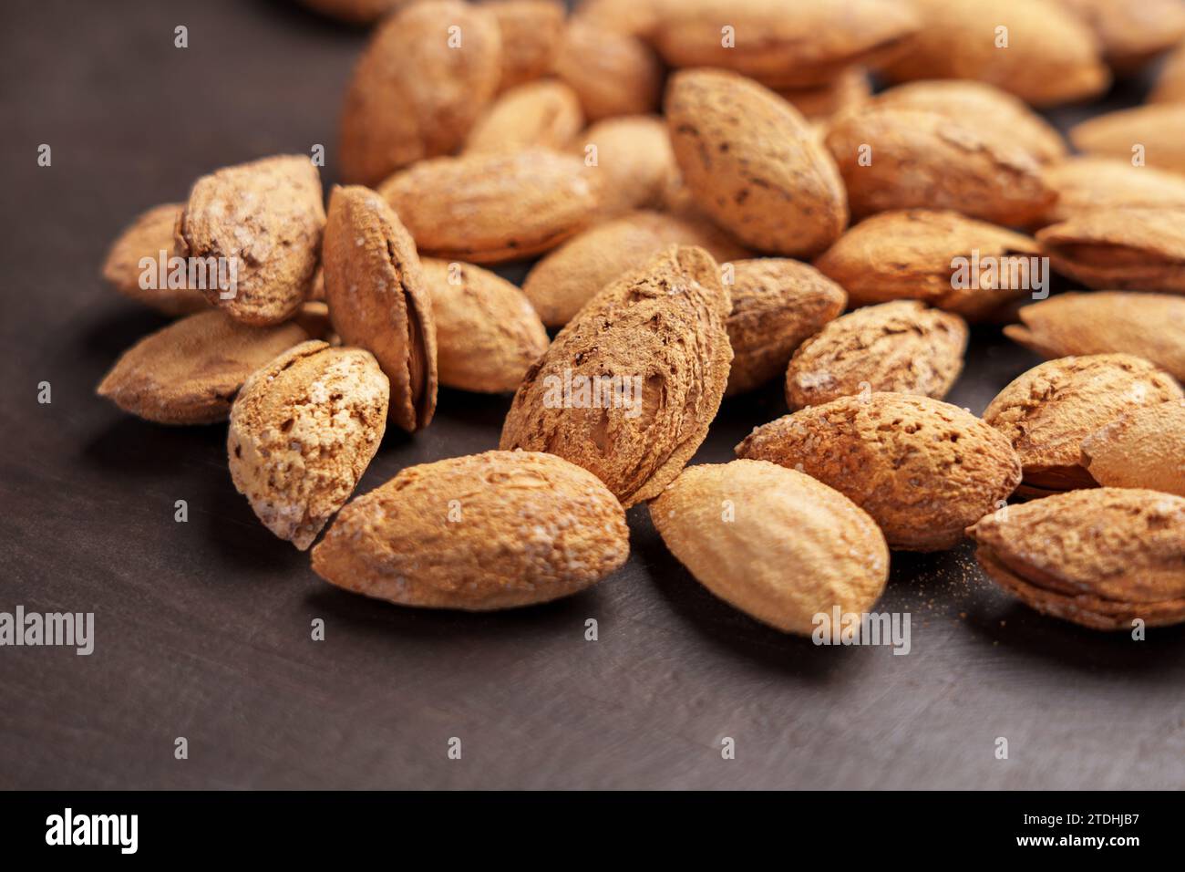 Wooden bowl with delicious roasted almond nuts with nutshell crack ...