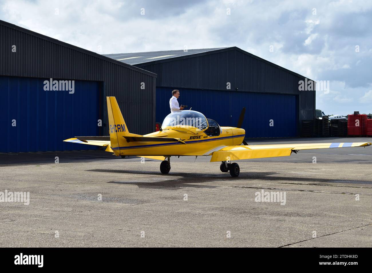 Student pilot holding a Bose headset while standing on the left wing of ...