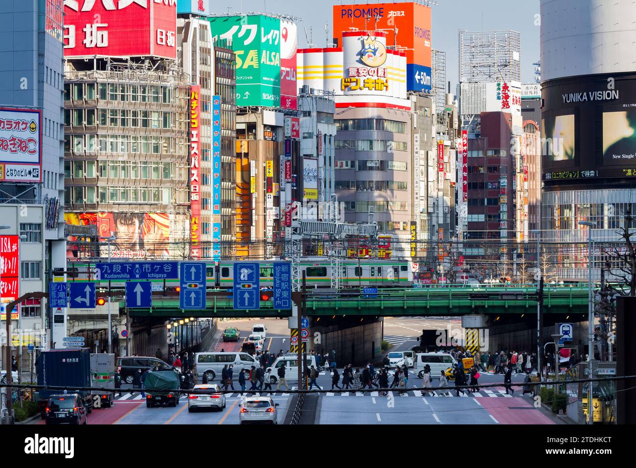 A Shonan Shinjuku Line train crosses a busy above a busy intersection ...