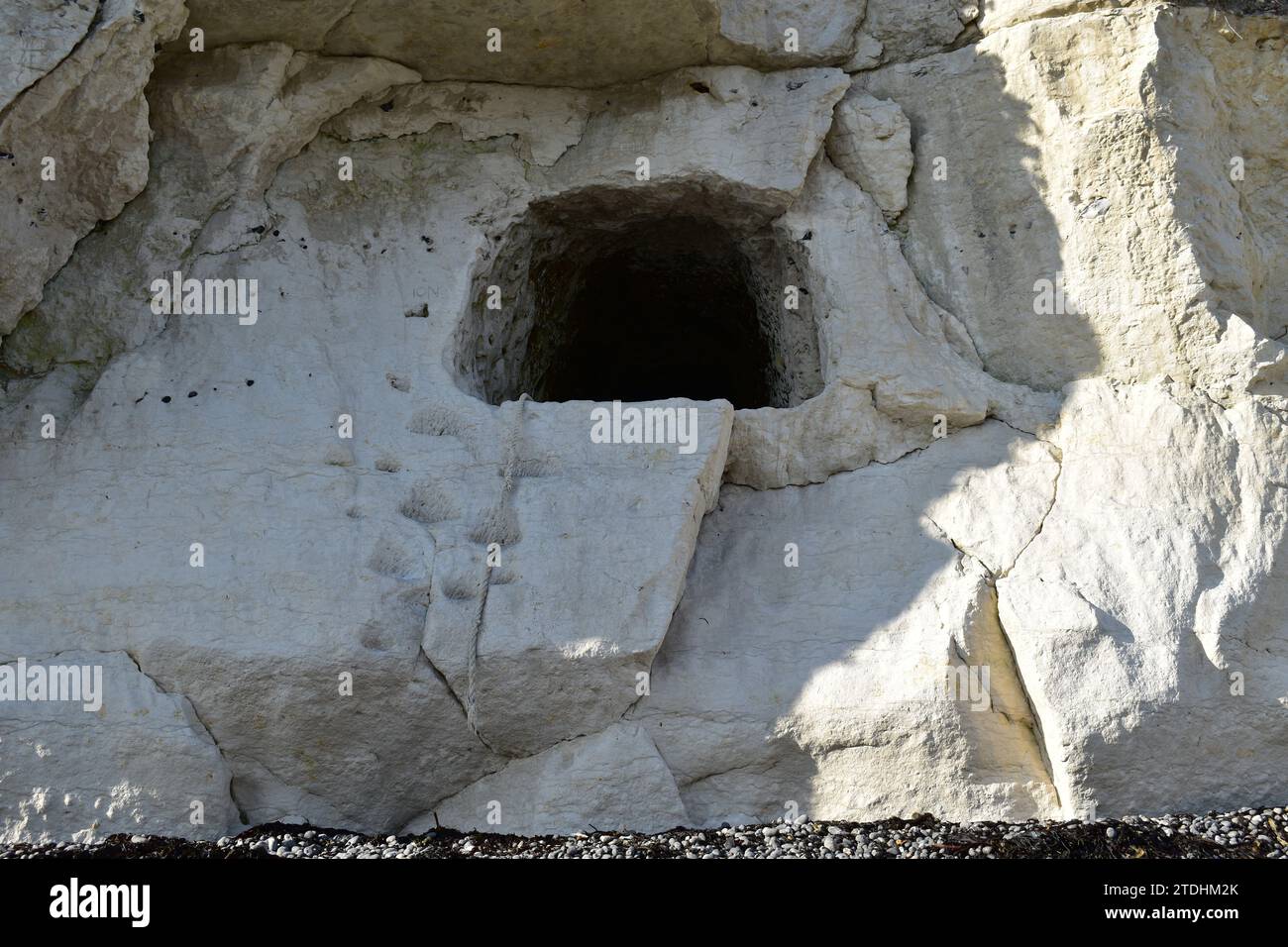 Cave entrance with climbing rope and carved out footsteps in the white ...