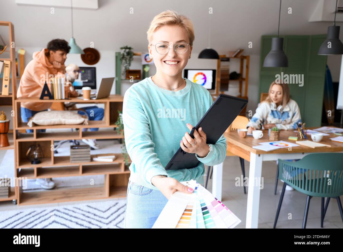 Female graphic designer with tablet and color palettes in office Stock ...