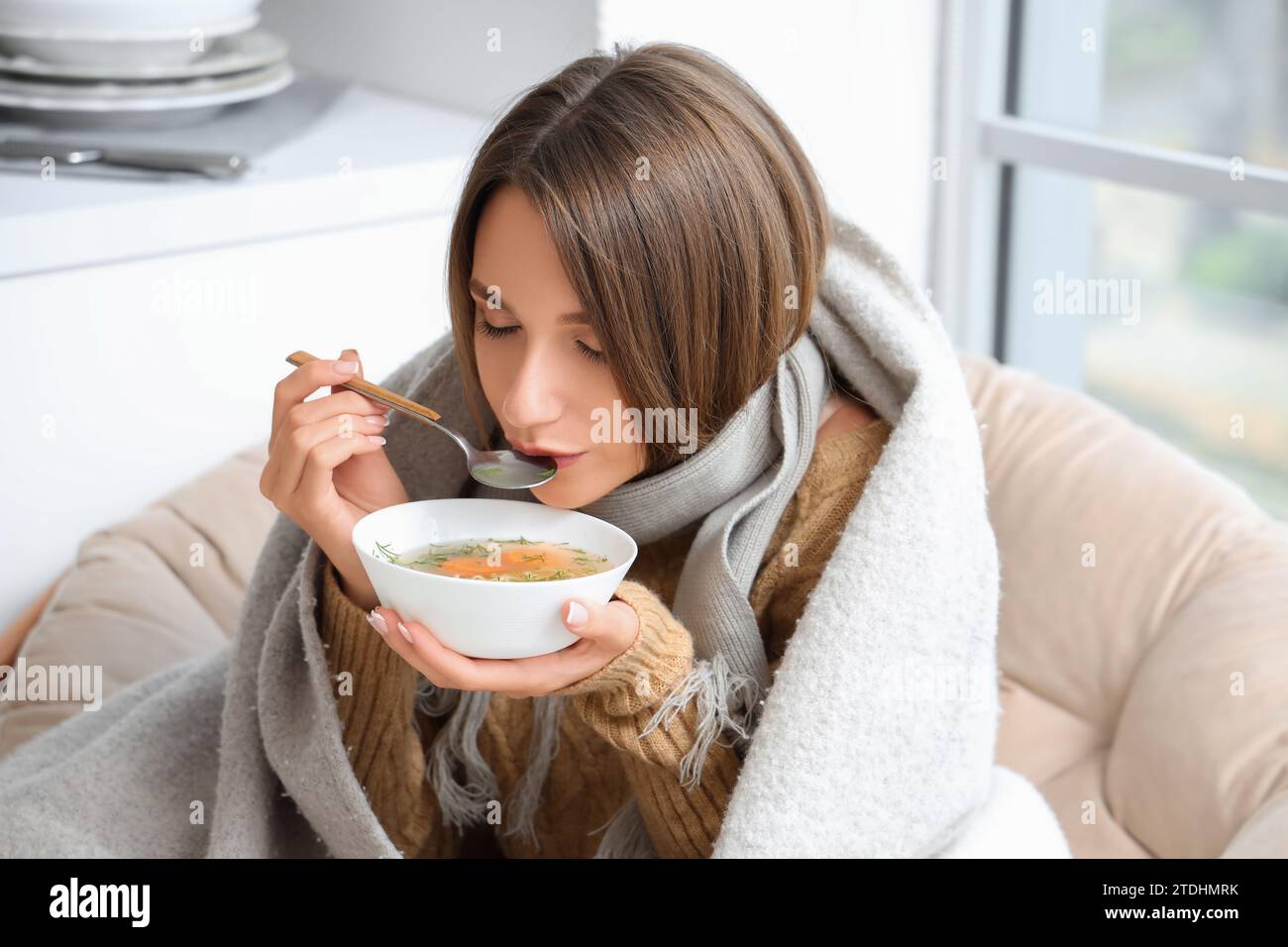 Ill young woman eating chicken soup at home, closeup Stock Photo - Alamy