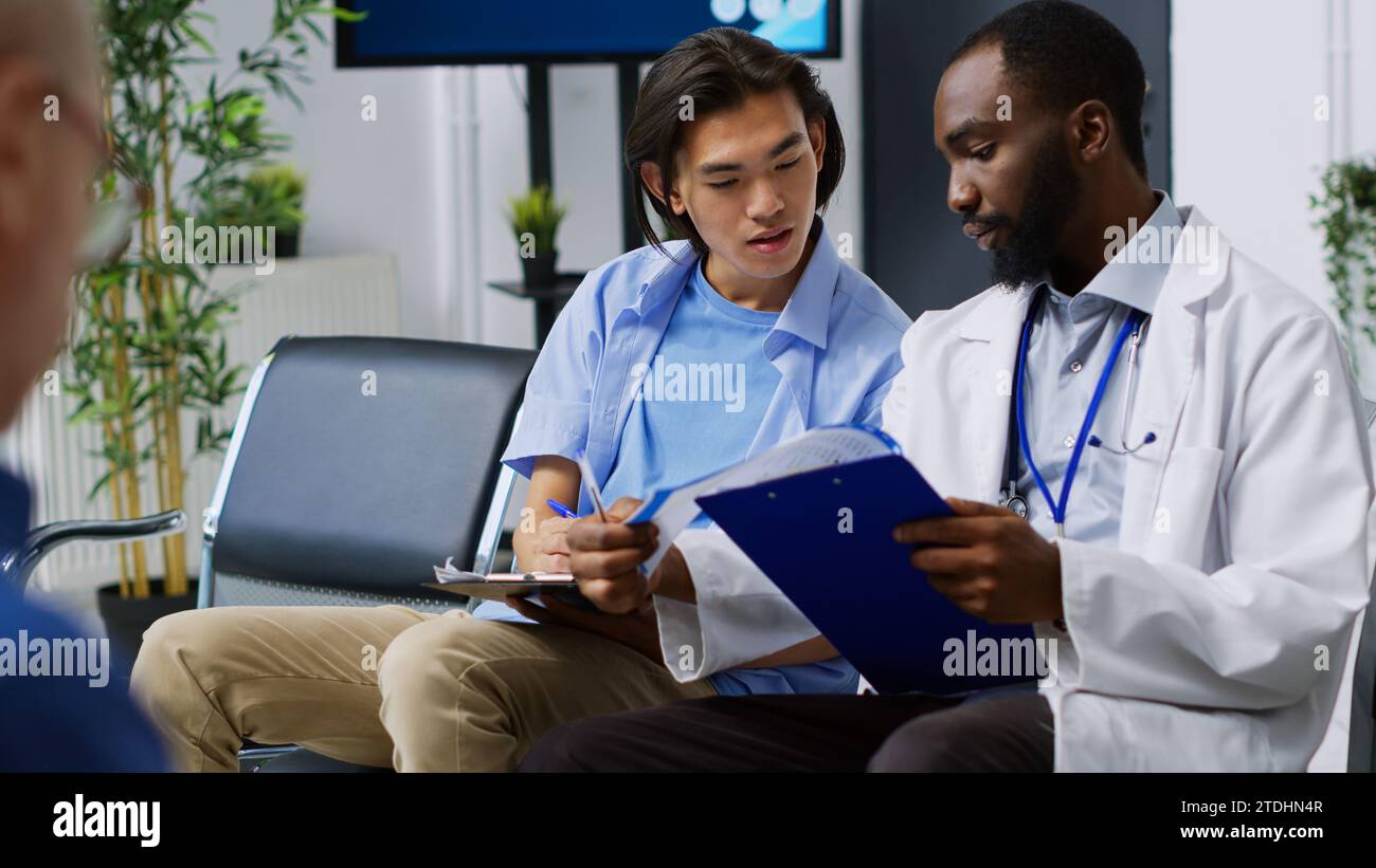 Medic helping patient to fill medical report, explaining disease ...