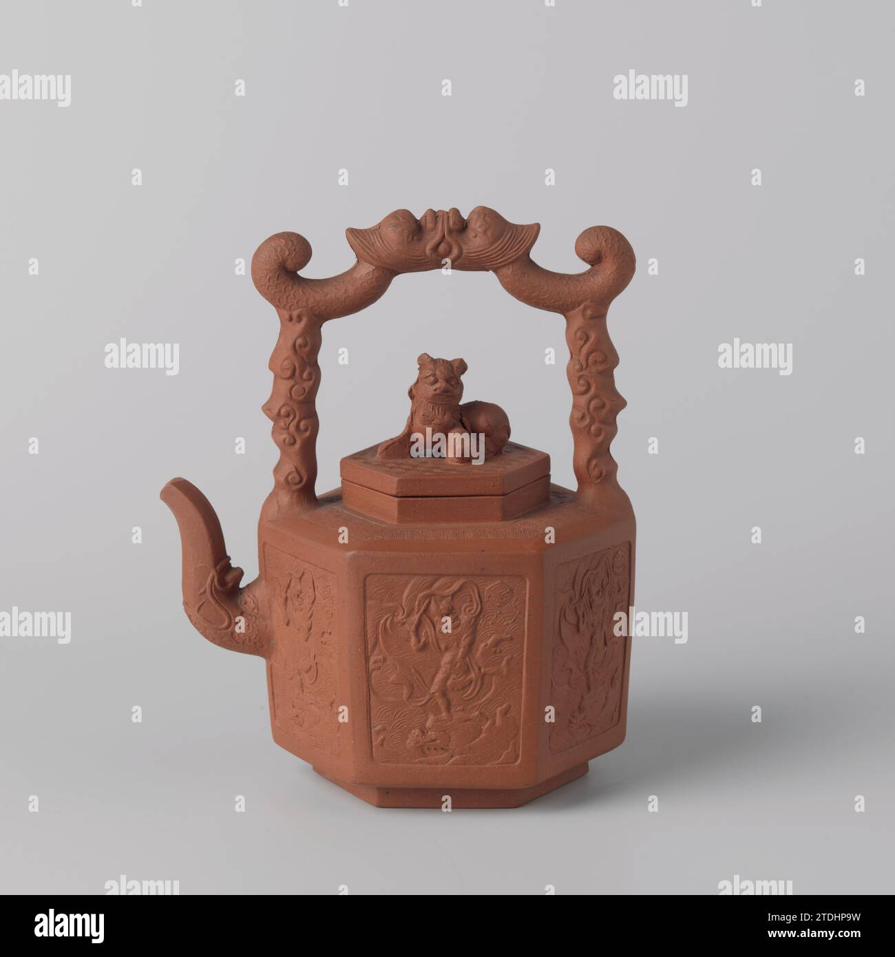 Hexagonal tea pot with a figure on a dragon's head amid waves ...