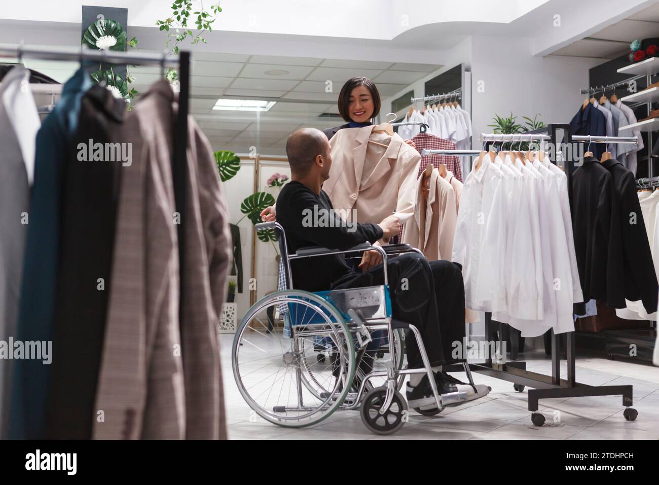 Clothing store smiling helpful employee consulting customer in ...